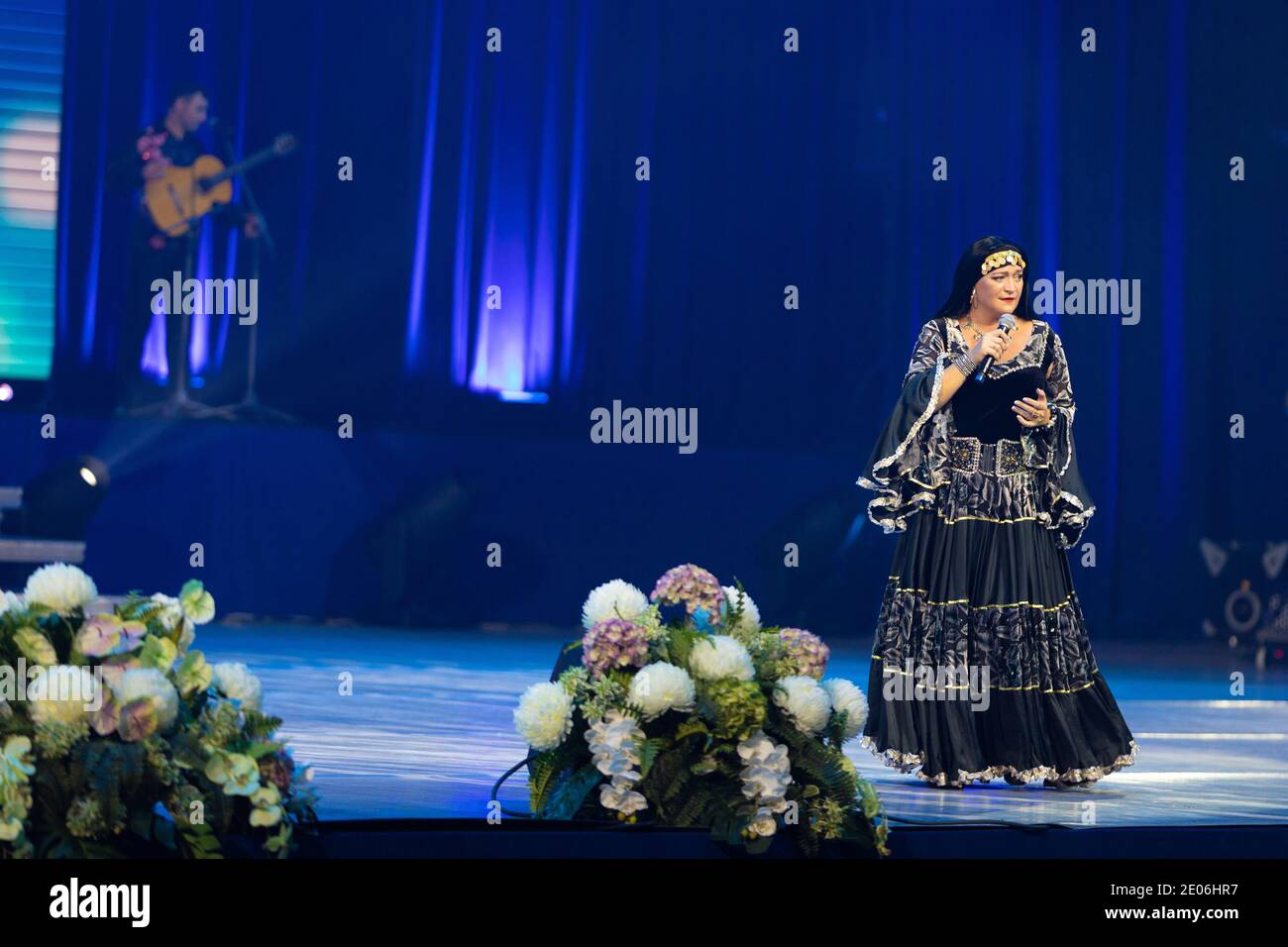 A team of musicians and singers perform on stage in front of the ...