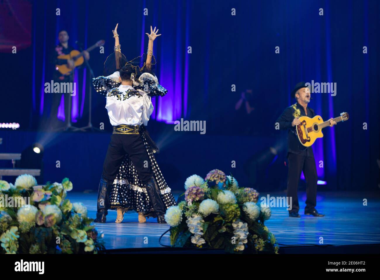 A team of musicians and singers perform on stage in front of the ...