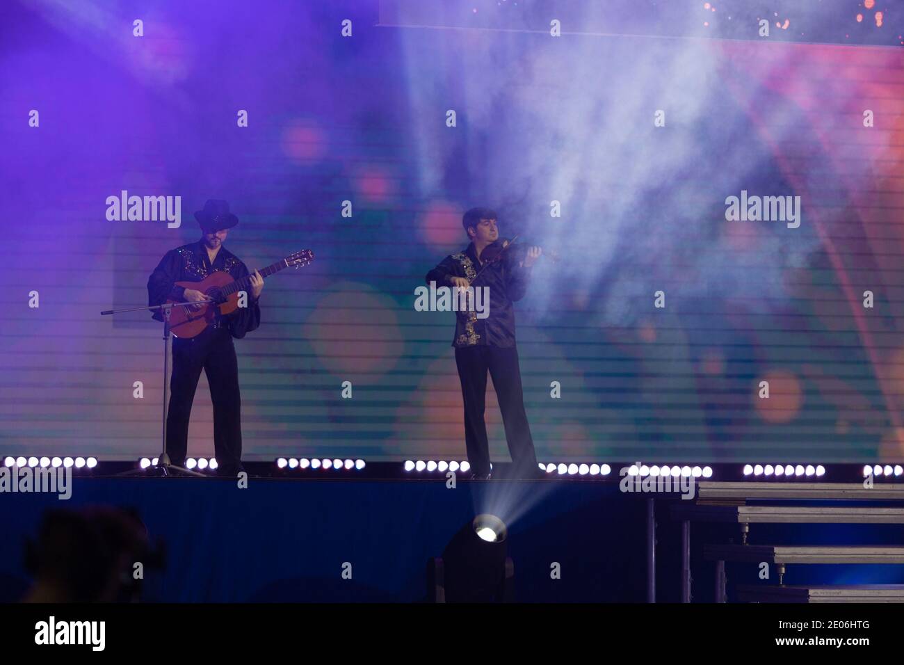 A team of musicians and singers perform on stage in front of the ...
