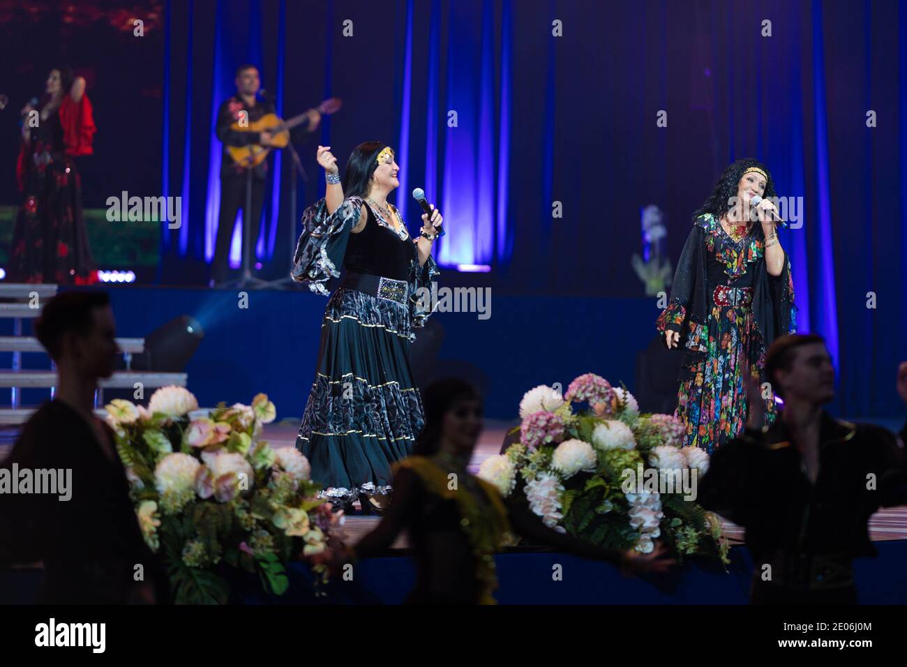 A team of musicians and singers perform on stage in front of the ...