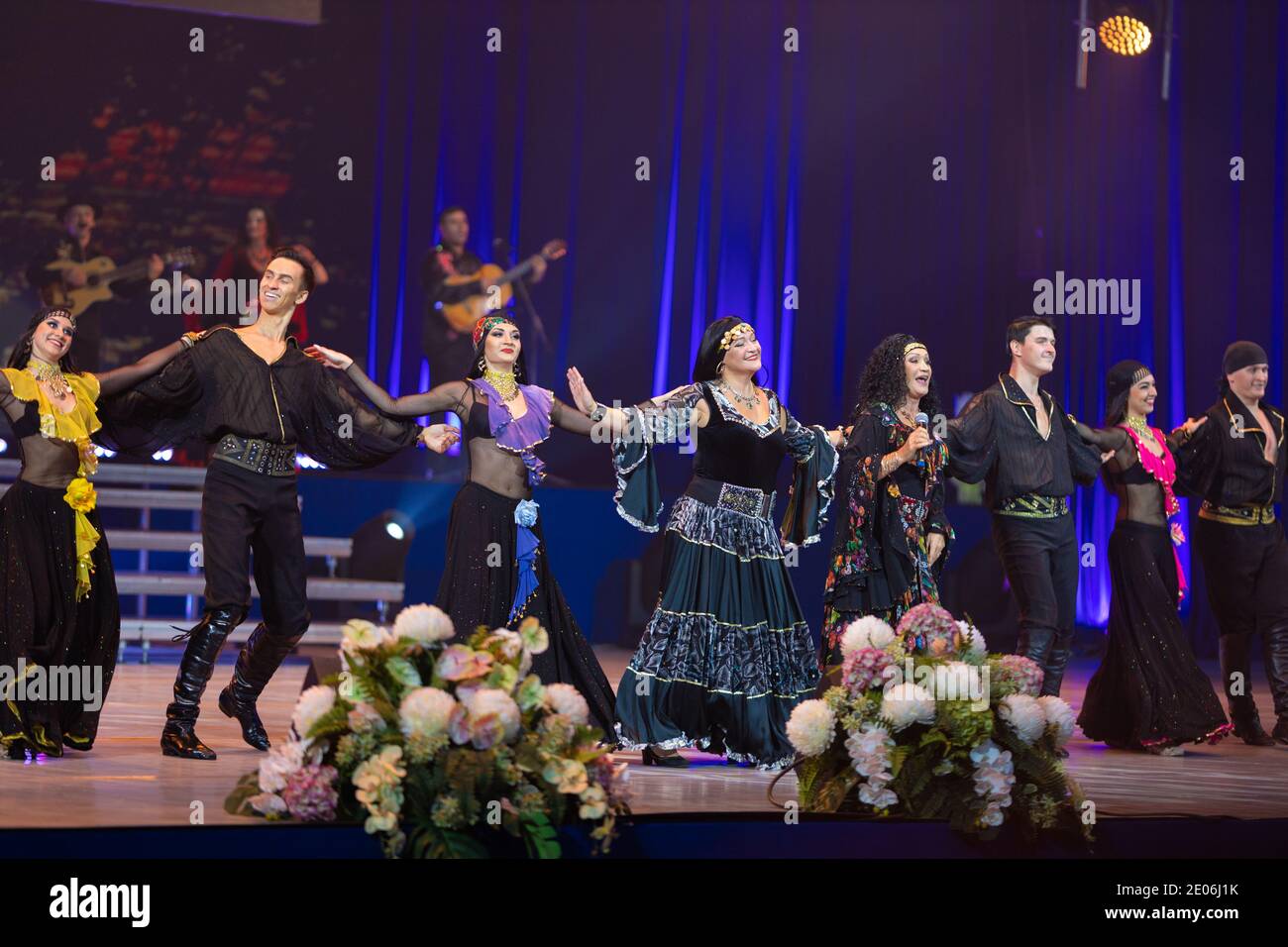 A team of musicians and singers perform on stage in front of the ...