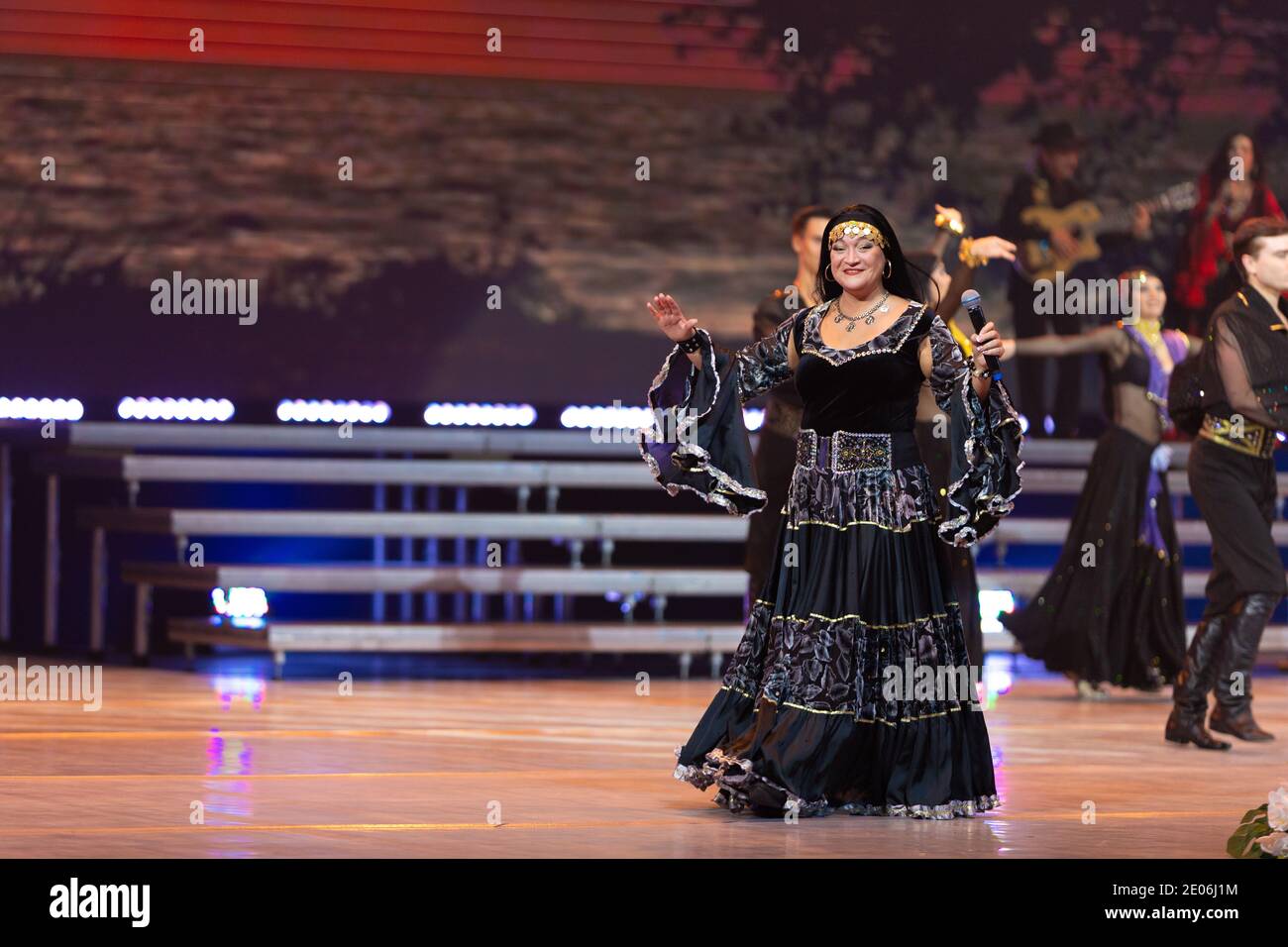 A team of musicians and singers perform on stage in front of the ...
