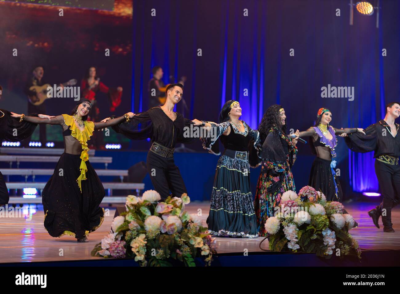A team of musicians and singers perform on stage in front of the ...