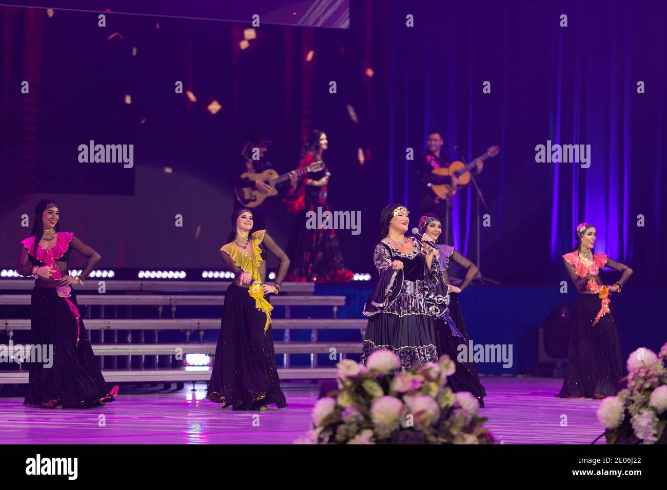 A team of musicians and singers perform on stage in front of the ...
