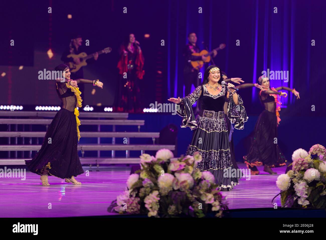 A team of musicians and singers perform on stage in front of the ...