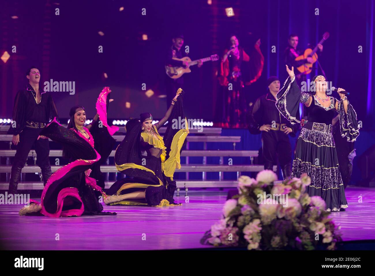 A team of musicians and singers perform on stage in front of the ...