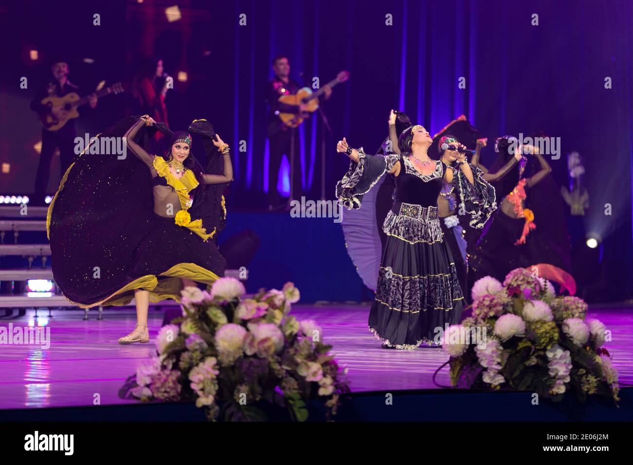 A team of musicians and singers perform on stage in front of the ...