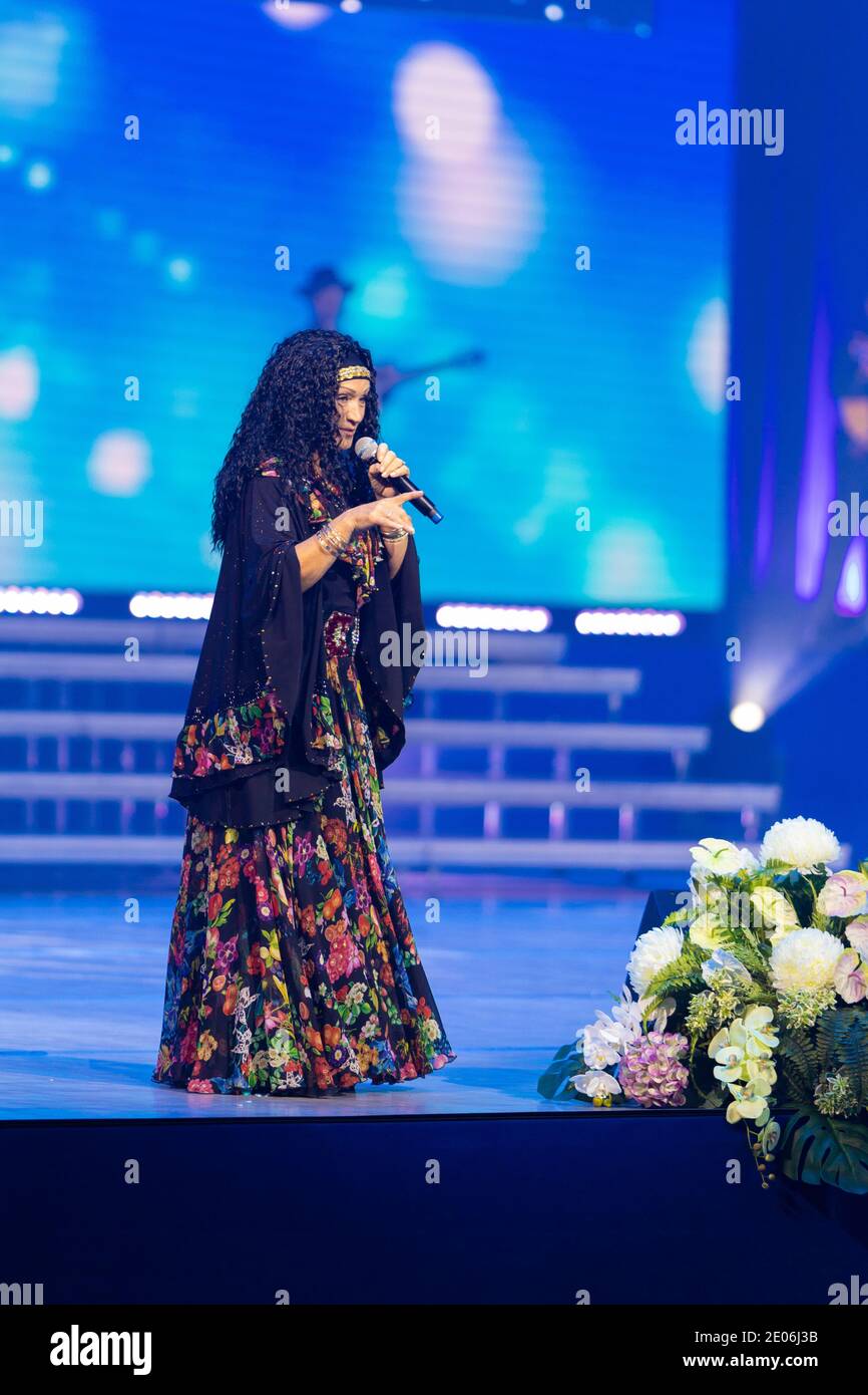 A team of musicians and singers perform on stage in front of the ...