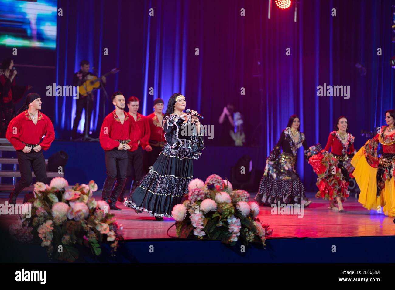 A team of musicians and singers perform on stage in front of the ...