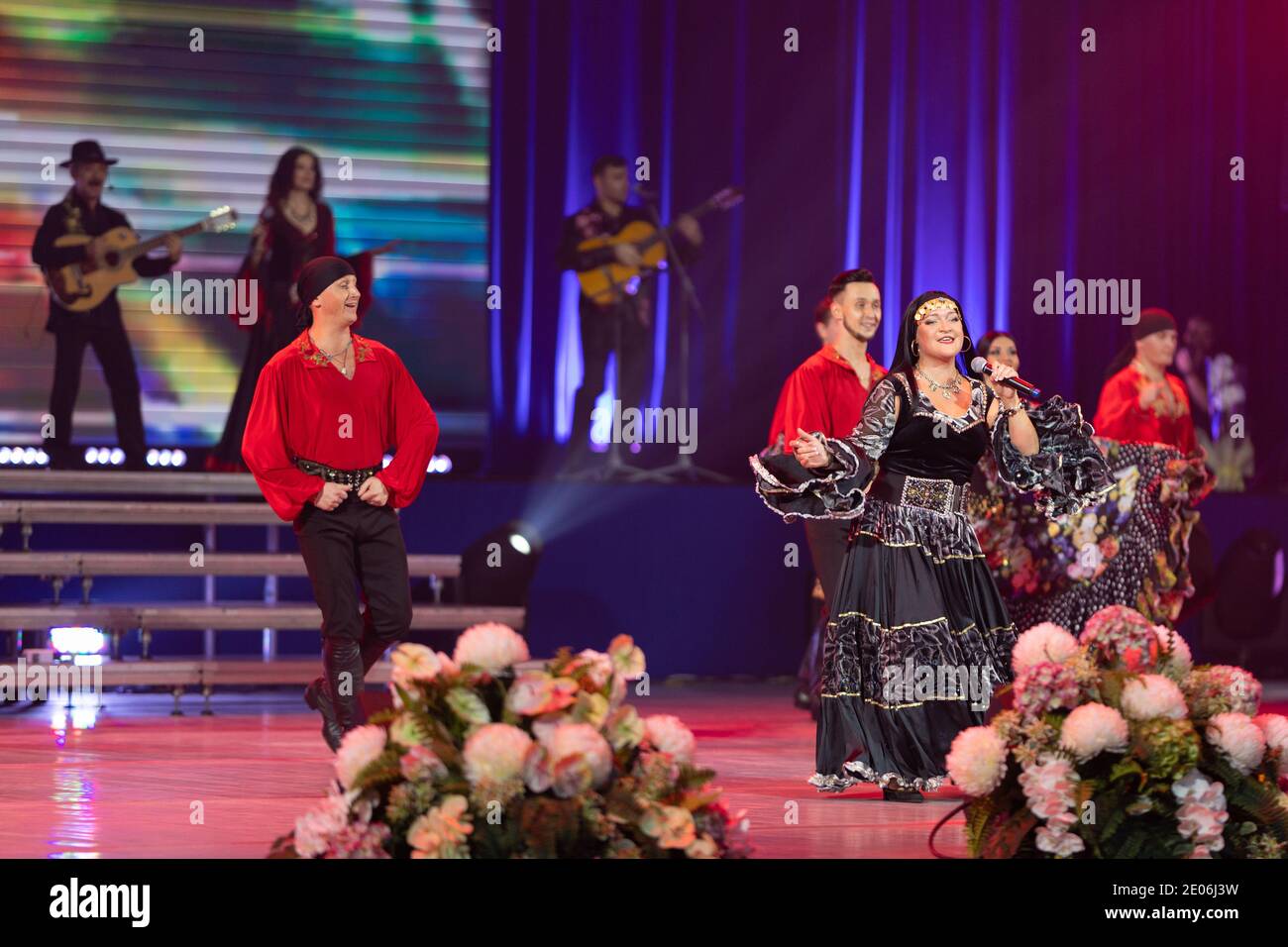 A team of musicians and singers perform on stage in front of the ...