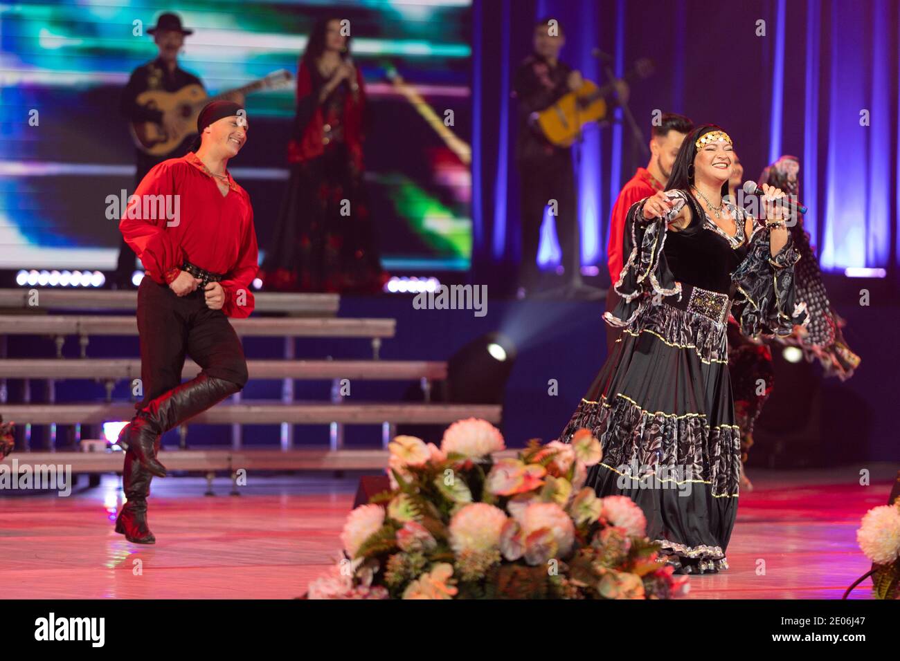 A team of musicians and singers perform on stage in front of the ...