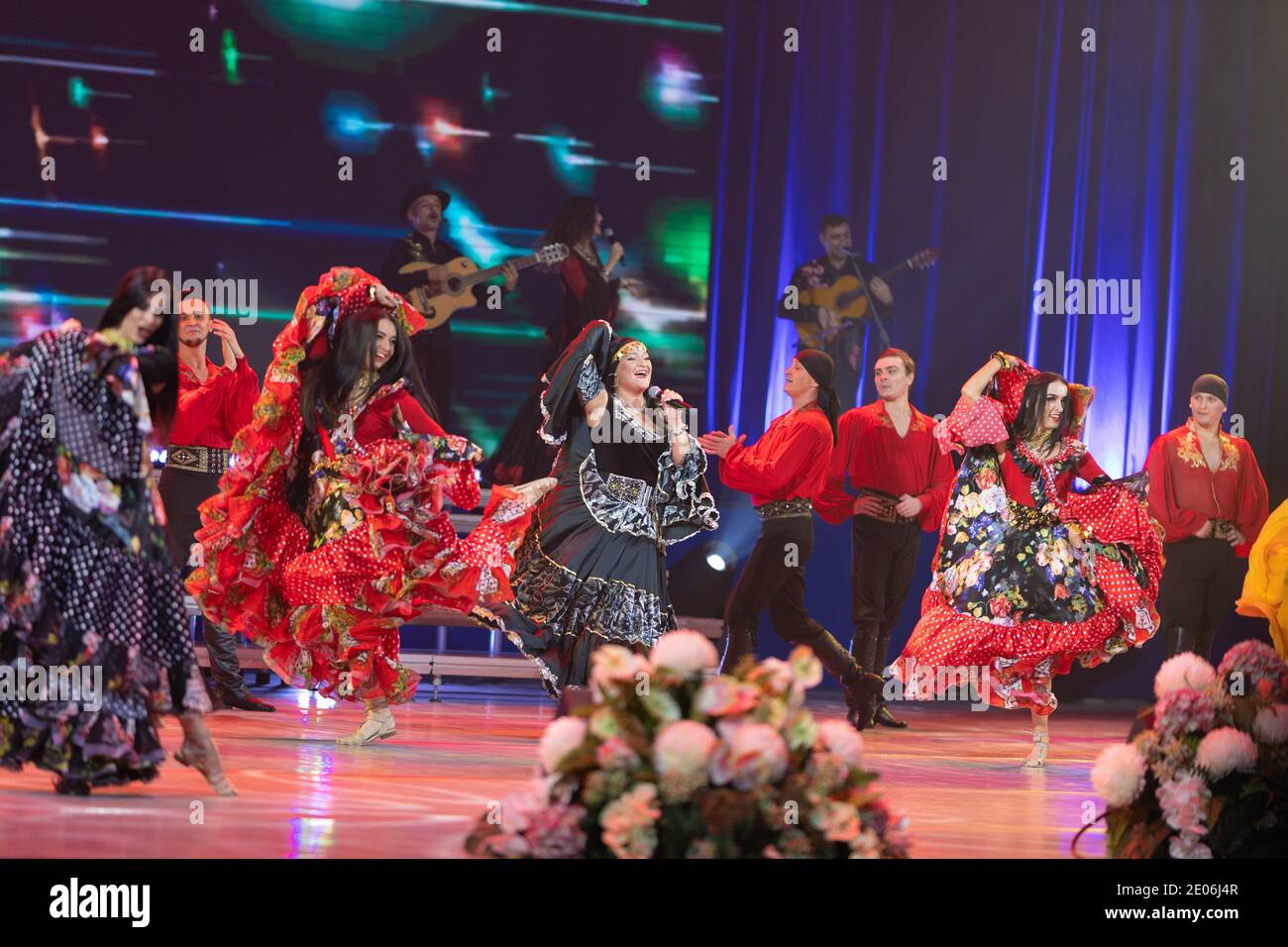 A team of musicians and singers perform on stage in front of the ...