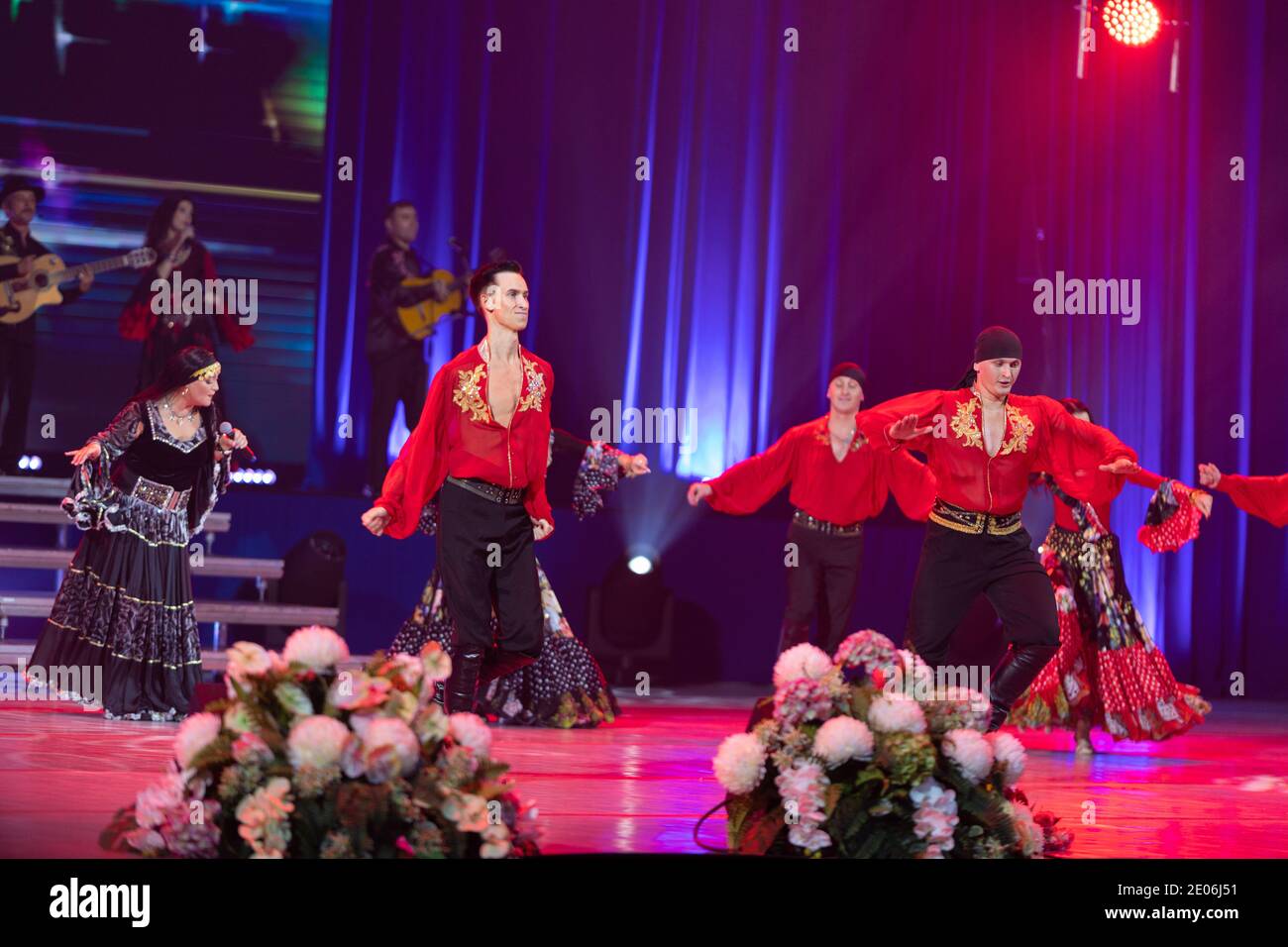 A team of musicians and singers perform on stage in front of the ...