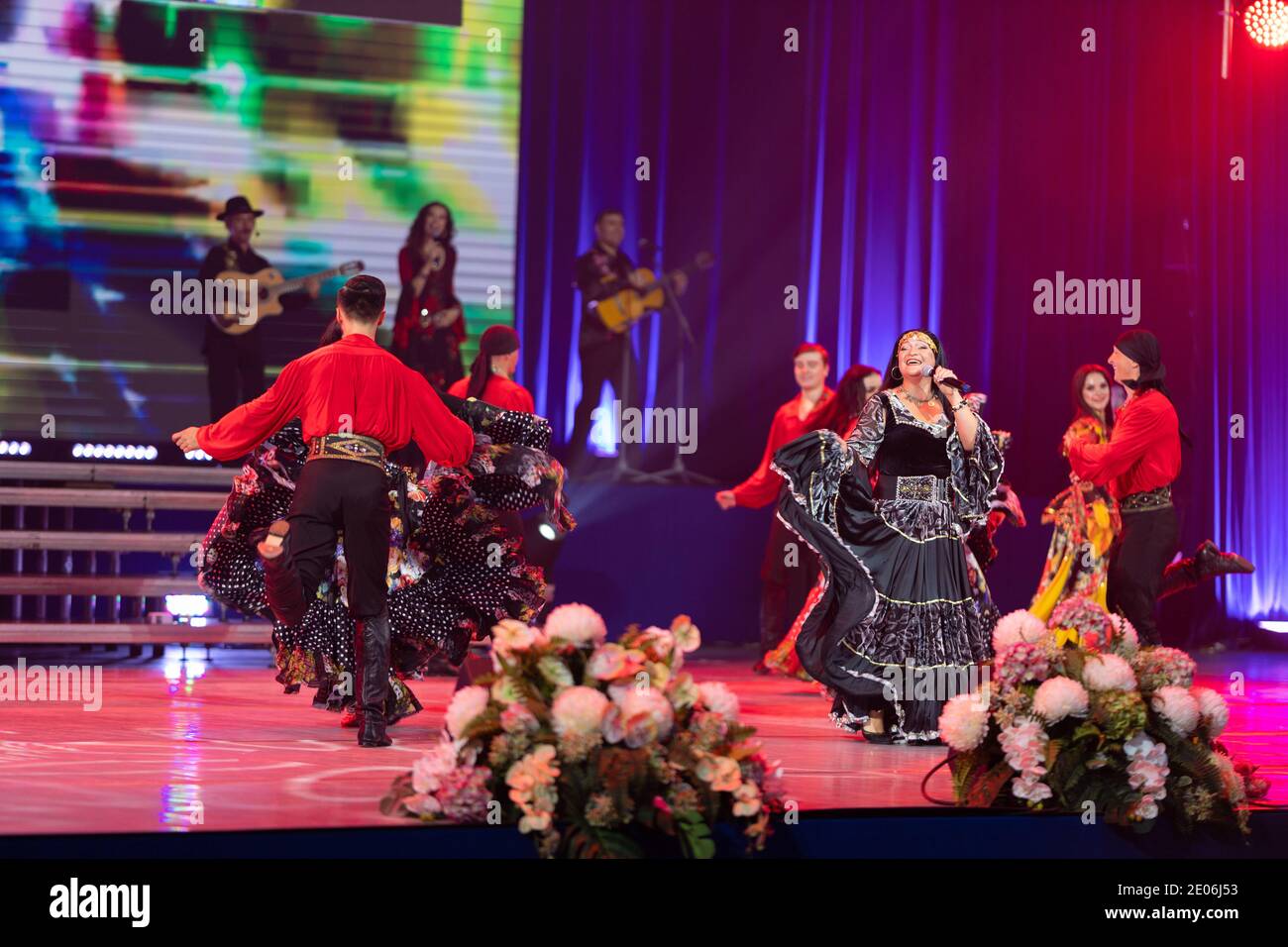 A team of musicians and singers perform on stage in front of the ...