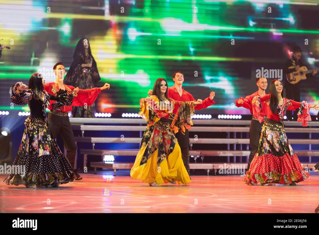 A team of musicians and singers perform on stage in front of the ...