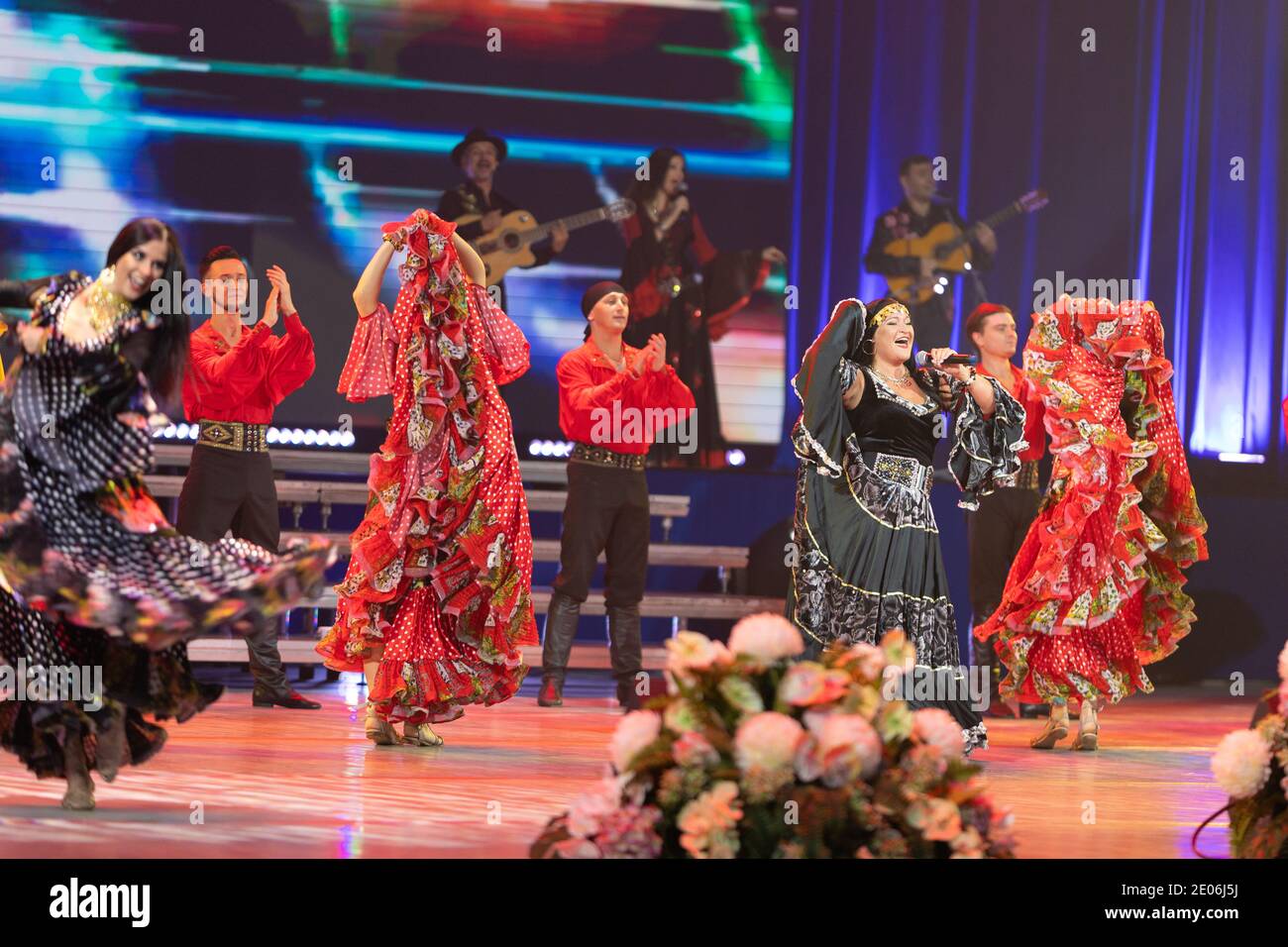 A team of musicians and singers perform on stage in front of the ...