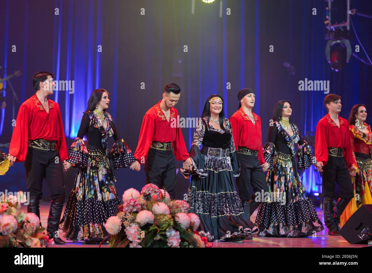 A team of musicians and singers perform on stage in front of the ...