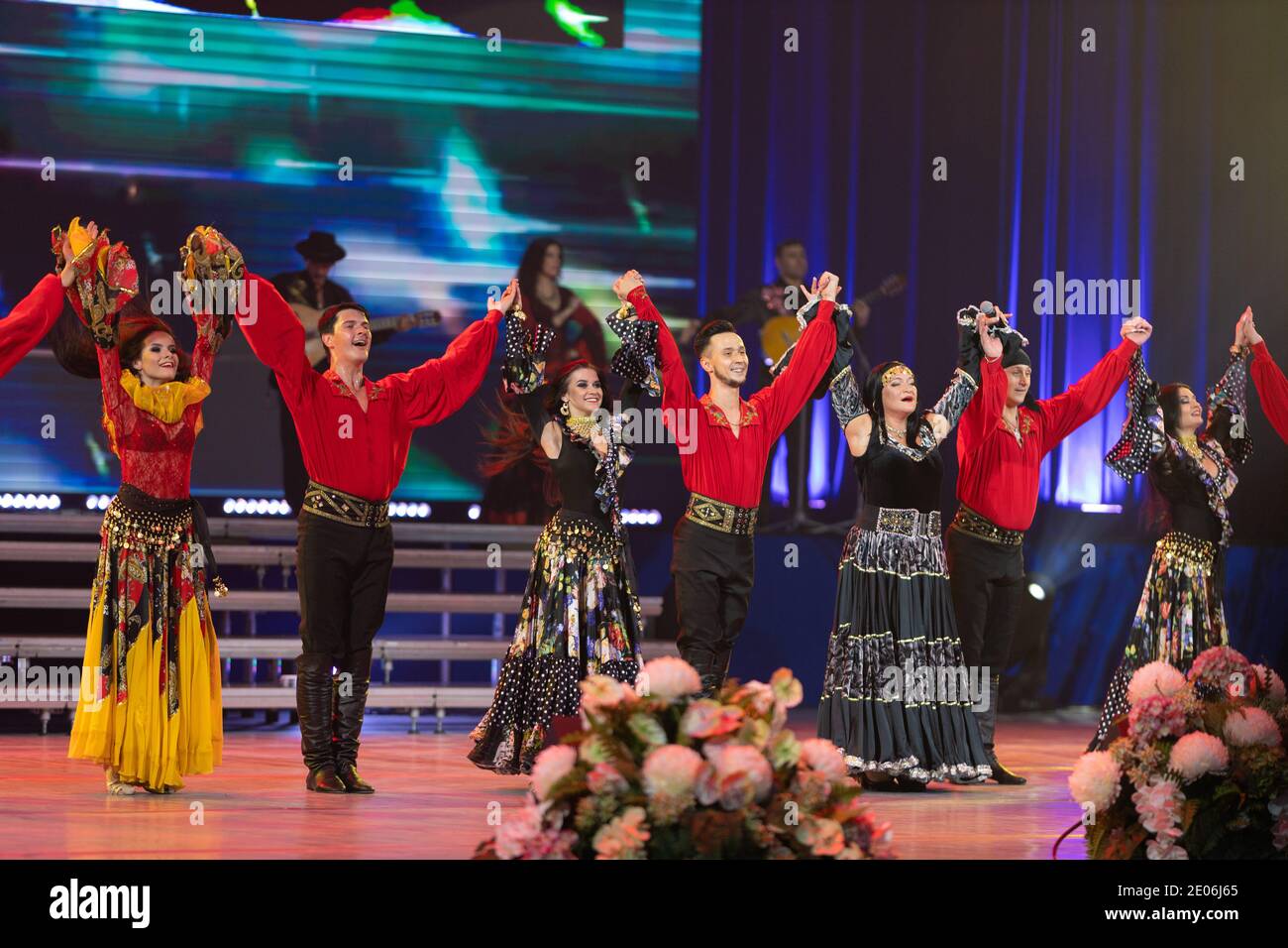 A team of musicians and singers perform on stage in front of the ...