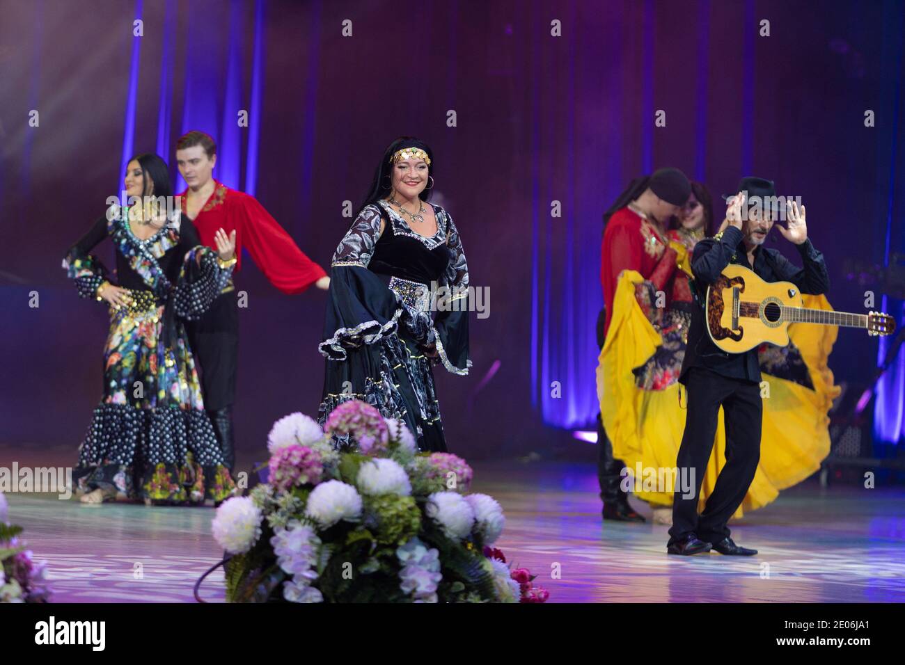 A team of musicians and singers perform on stage in front of the ...