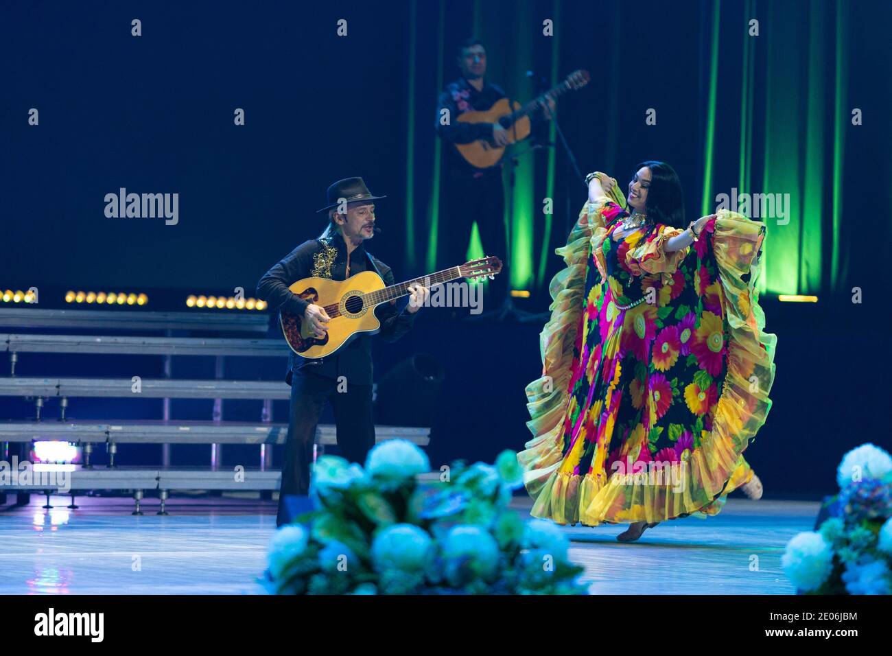 A team of musicians and singers perform on stage in front of the ...