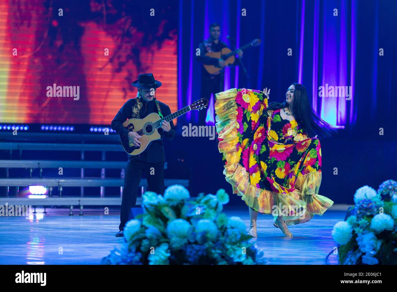 A team of musicians and singers perform on stage in front of the ...
