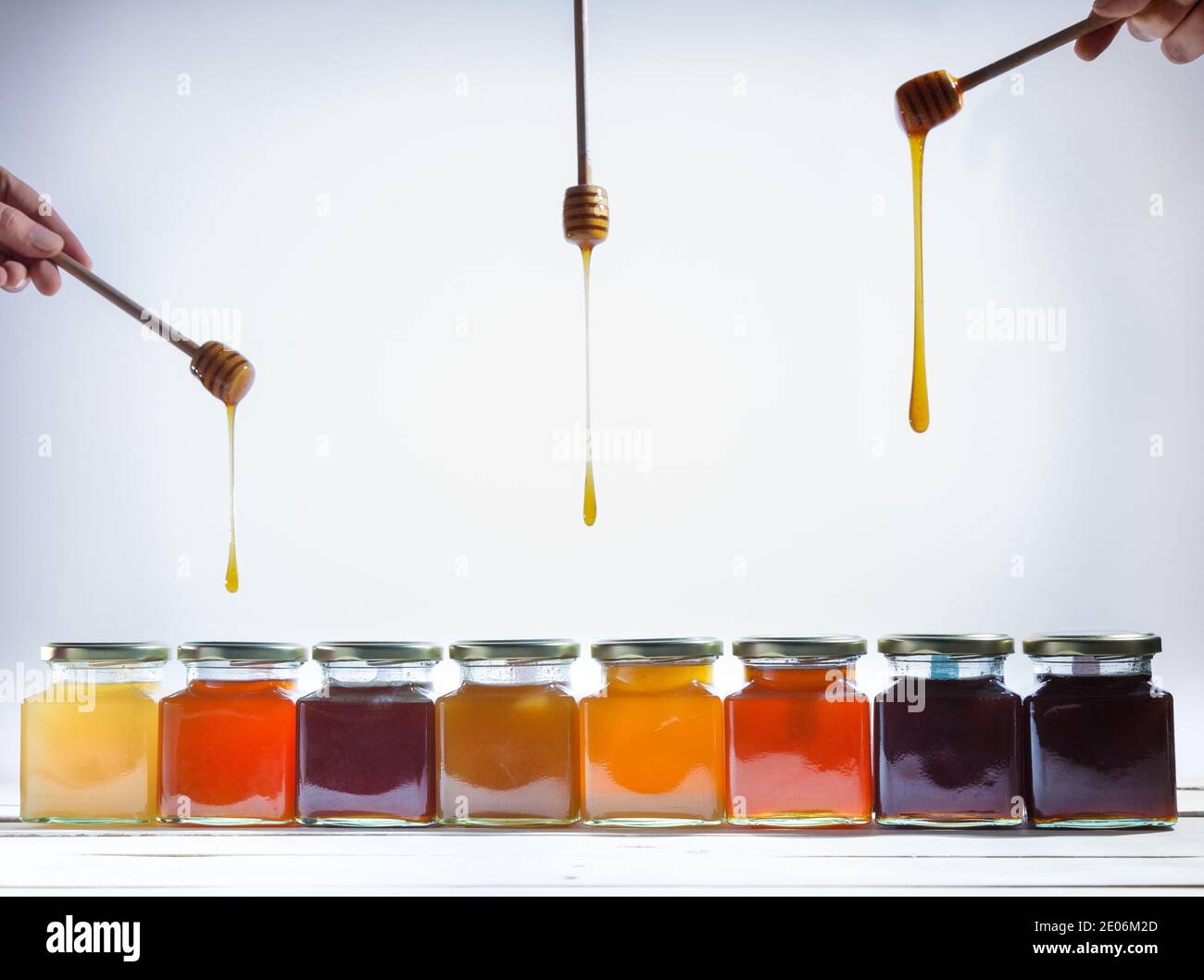jars of honey, and sticks spilling honey on white background Stock ...