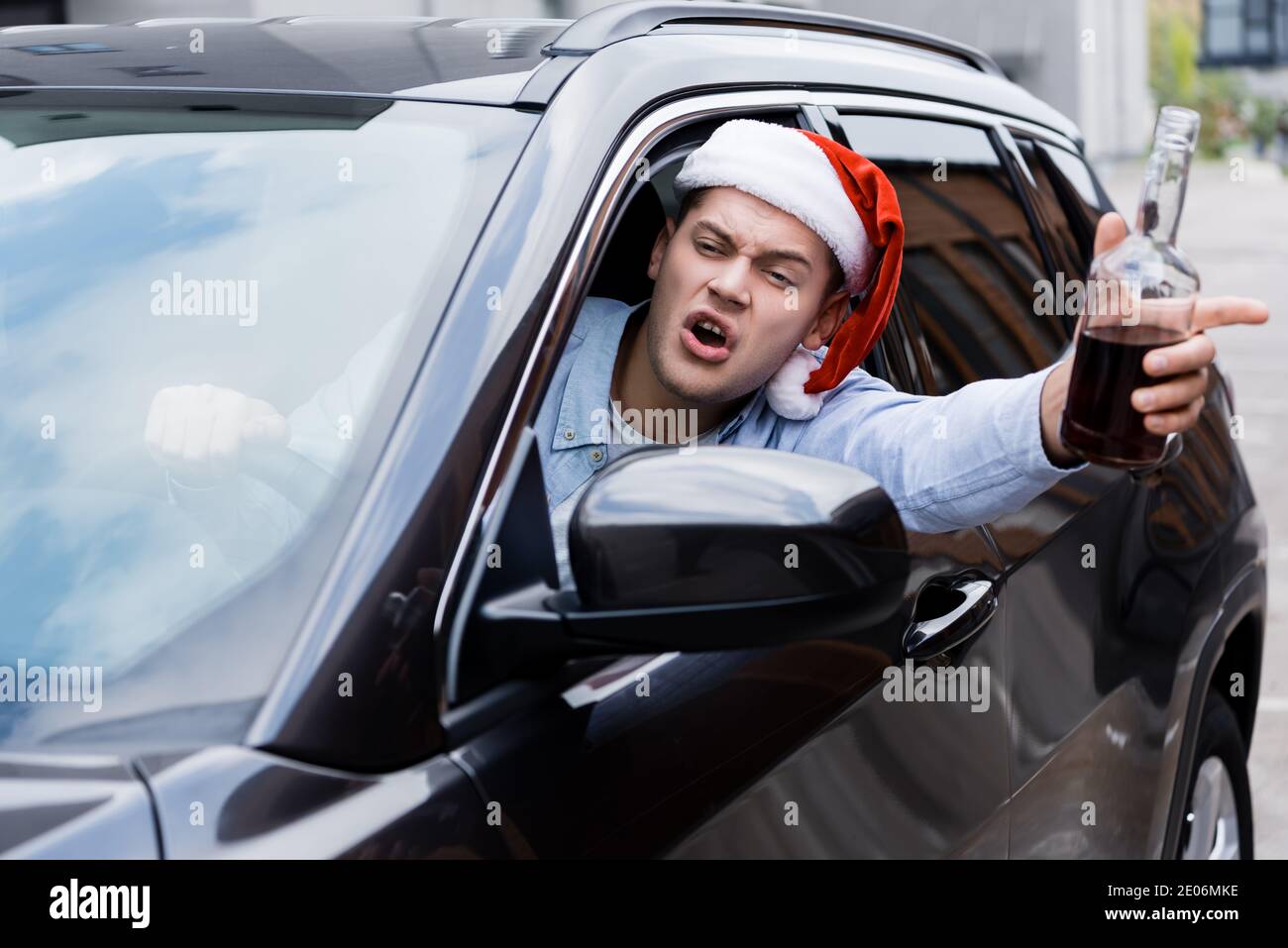 drunk, angry man in santa hat, with bottle of whiskey, looking out ...