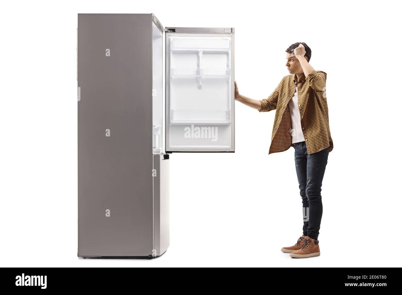 Young man in panic looking at an empty fridge isolated on white ...