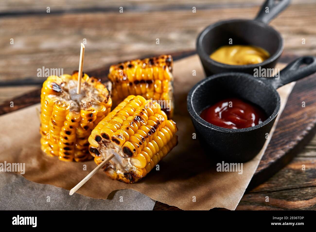 Corn grilled with salt and spices. Dark background. Fast food in the ...
