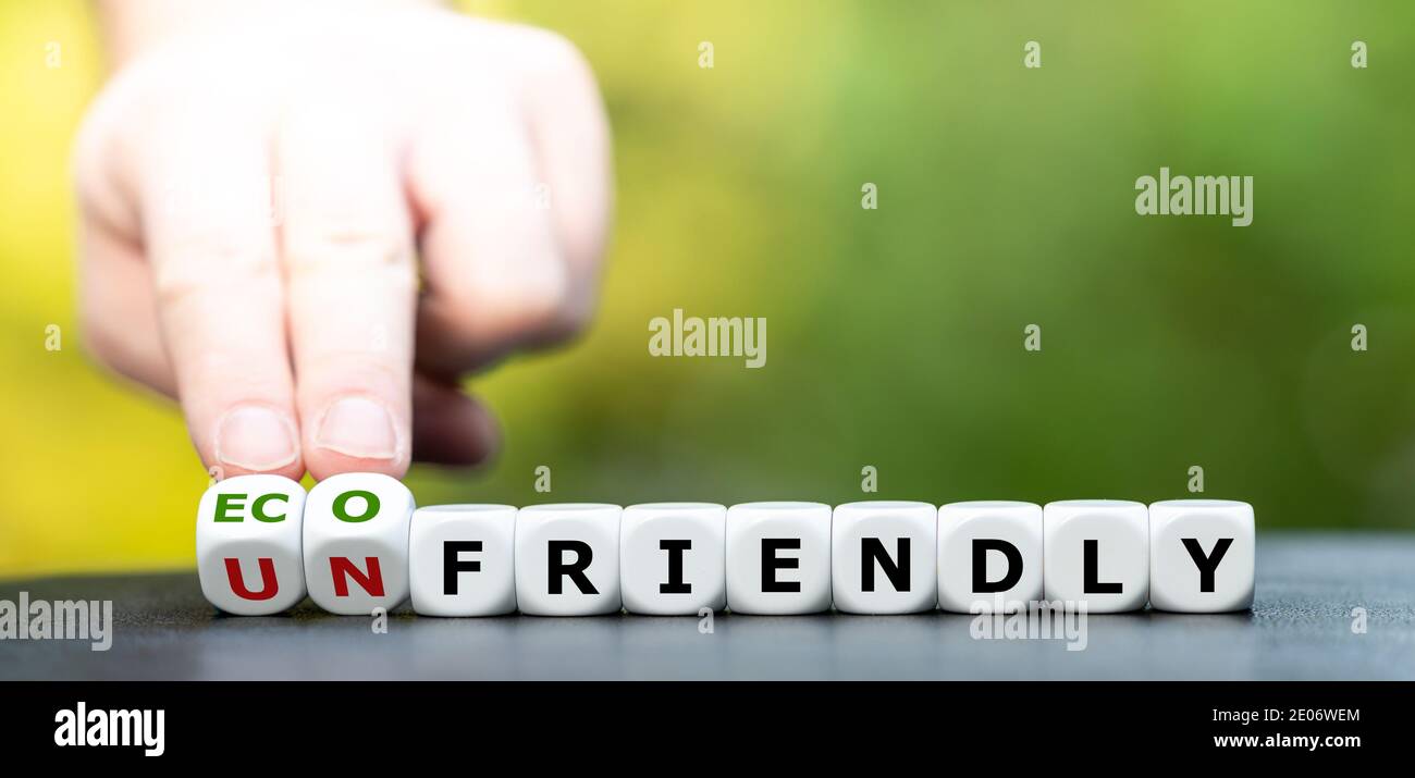 Hand turns dice and changes the expression "unfriendly" to "eco ...