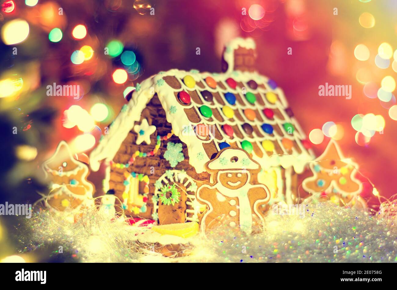 gingerbread house with blurred garland lights background Stock Photo ...