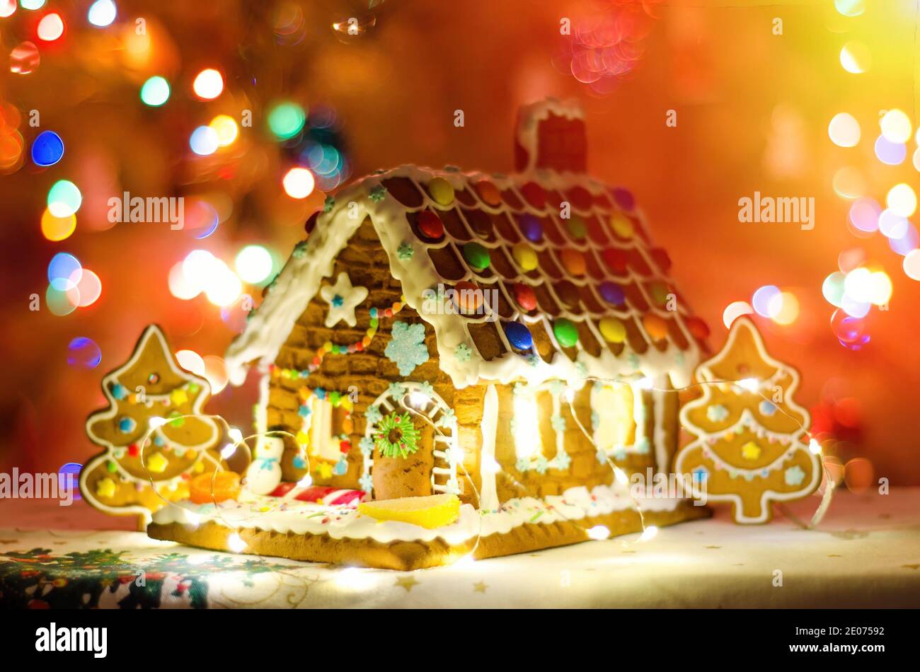 gingerbread house with blurred garland lights background Stock Photo ...
