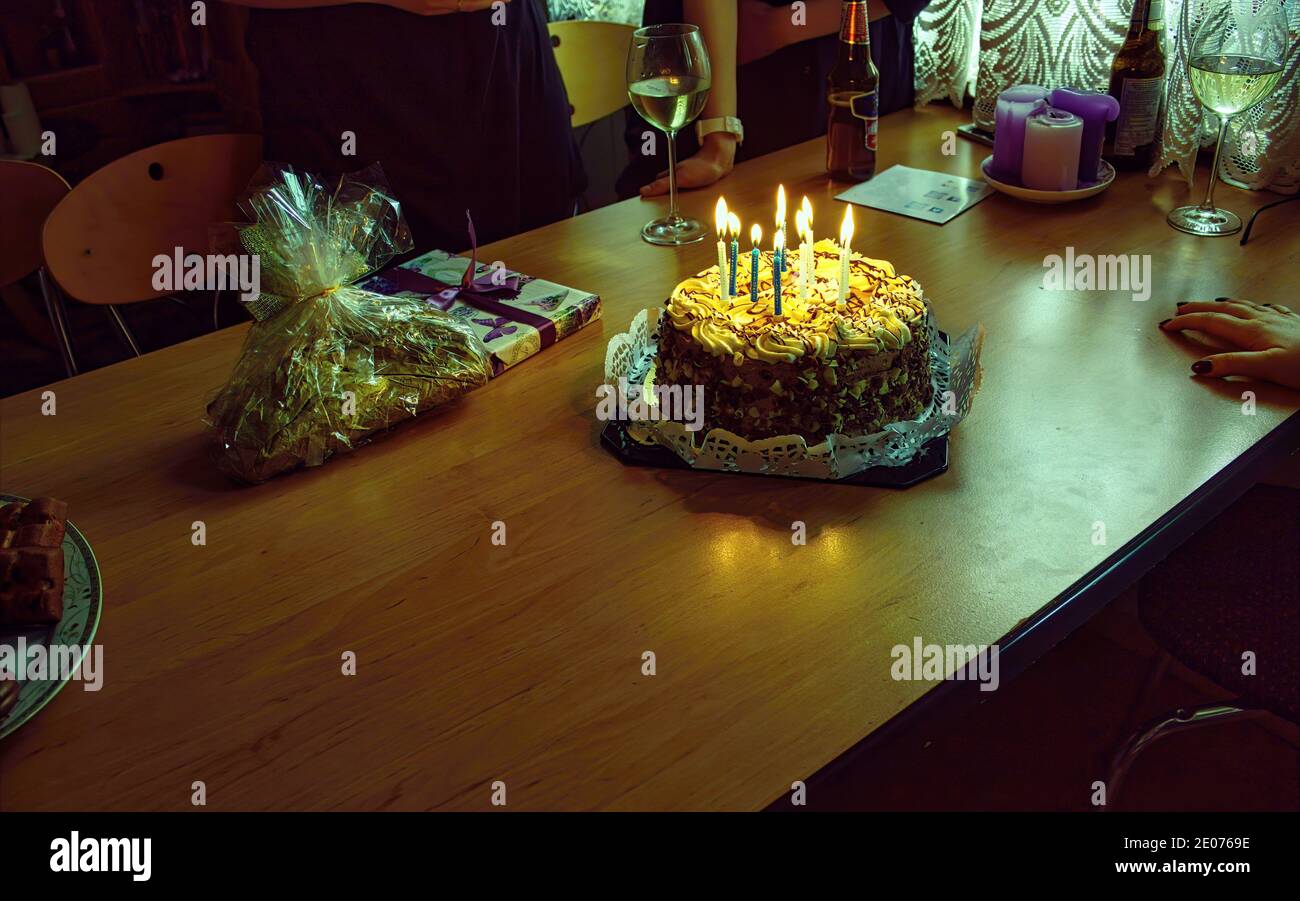 A Birthday cake with candles kept on a table with gifts during Birthday ...