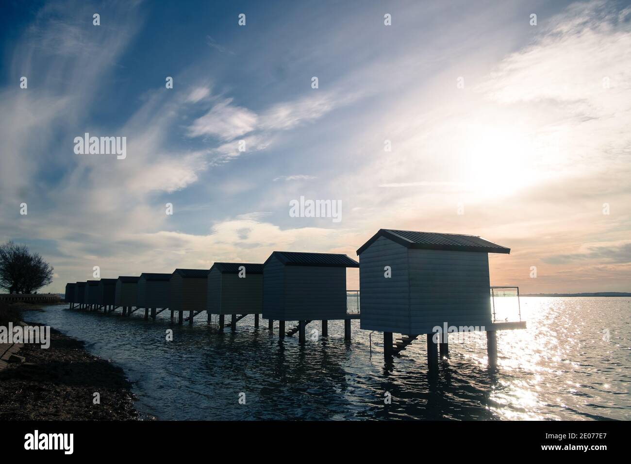 Modern beach huts on stilts in the River Blackwater at Tollesbury Essex ...