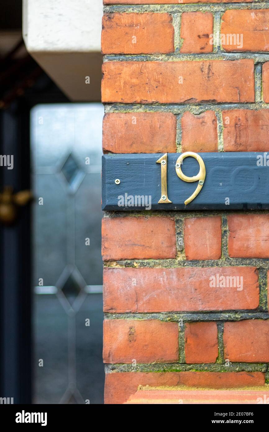 On a blue plaque on a red brick wall is house number 19 Stock Photo - Alamy