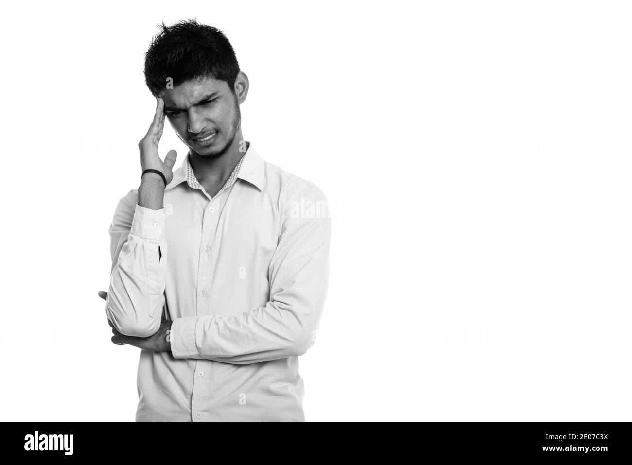 Studio shot of young stressed Indian man having headache Stock Photo ...