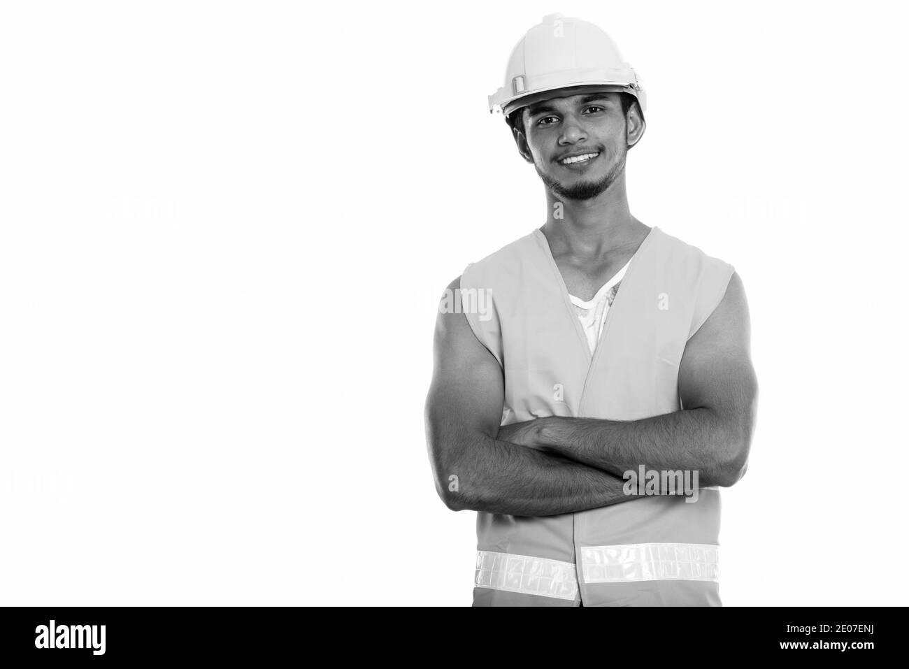 Studio shot of young happy Indian man construction worker smiling with ...