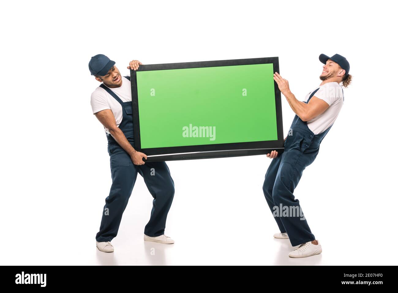 full length of multicultural movers carrying heavy plasma tv with green ...