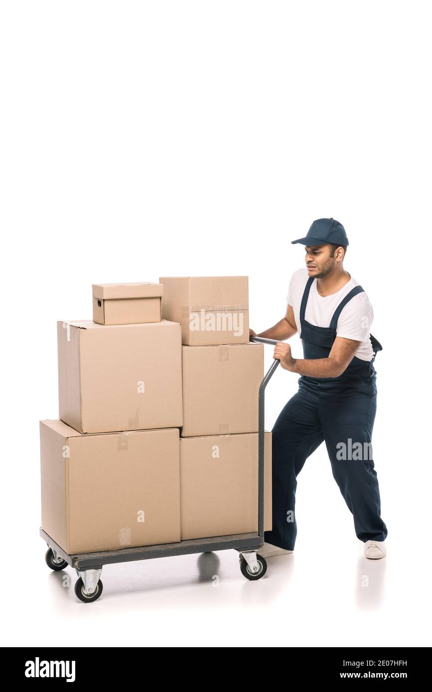 full length of indian mover in overalls pulling heavy hand truck with ...