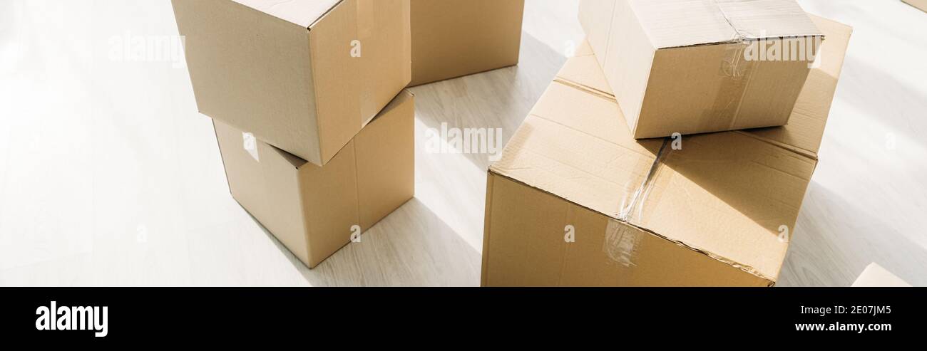 stacked carton boxes on floor in modern apartment, banner Stock Photo ...