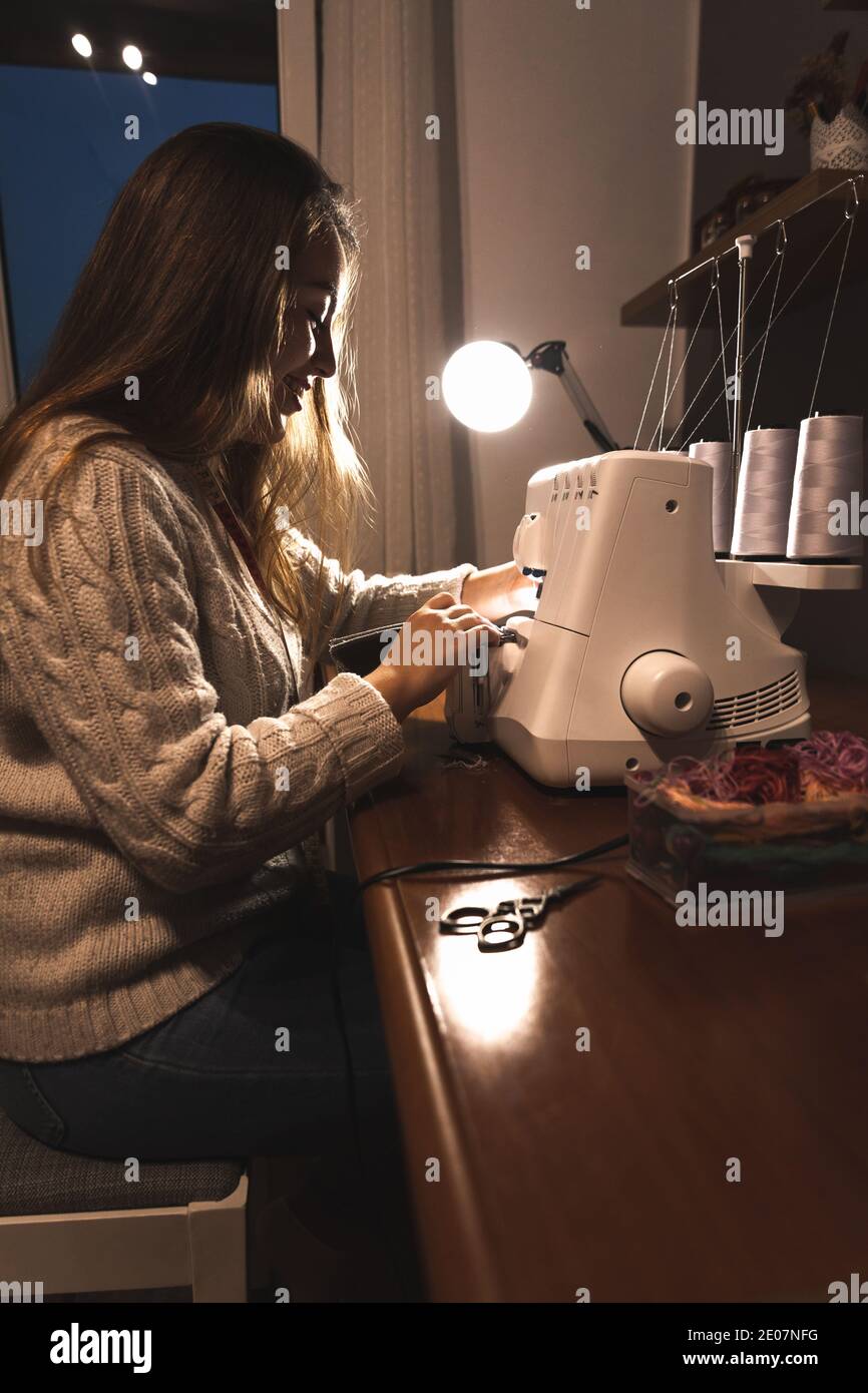 Young woman using a sewing machine Stock Photo - Alamy