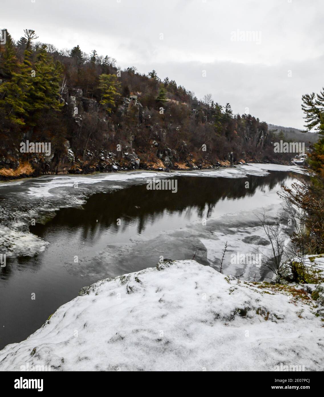 Icy snow and rocks along the river forest and trees in winter Stock ...