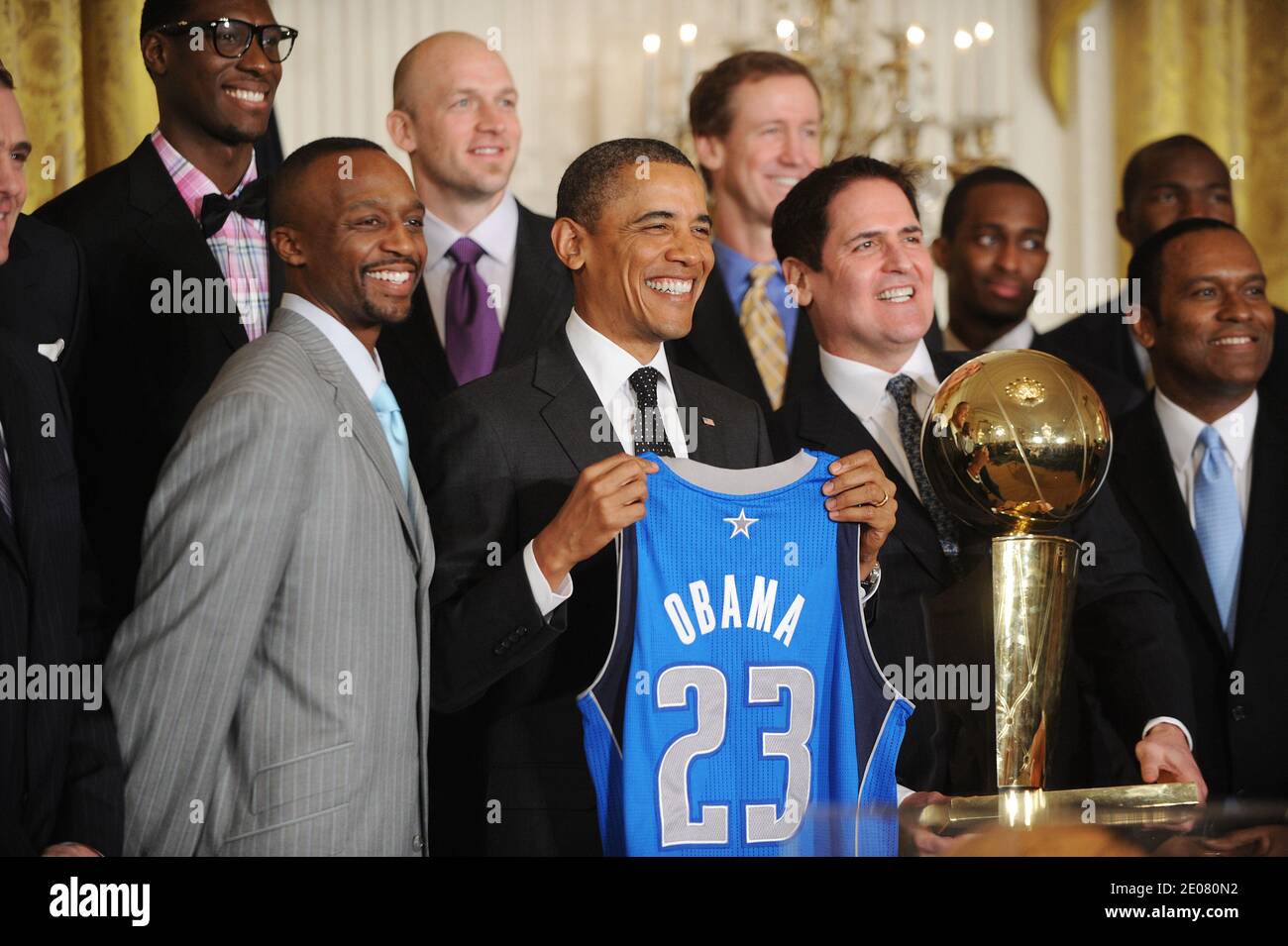 President Barack Obama holds a jersey as he poses at a ceremony with ...