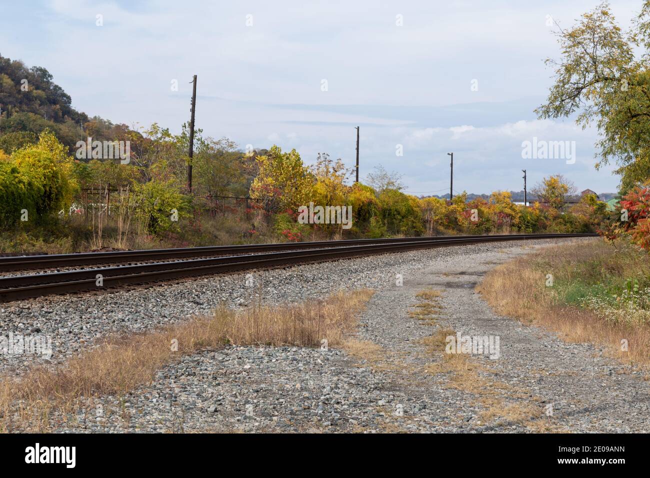 Curved train tracks running through a rural area, fall landscape with ...