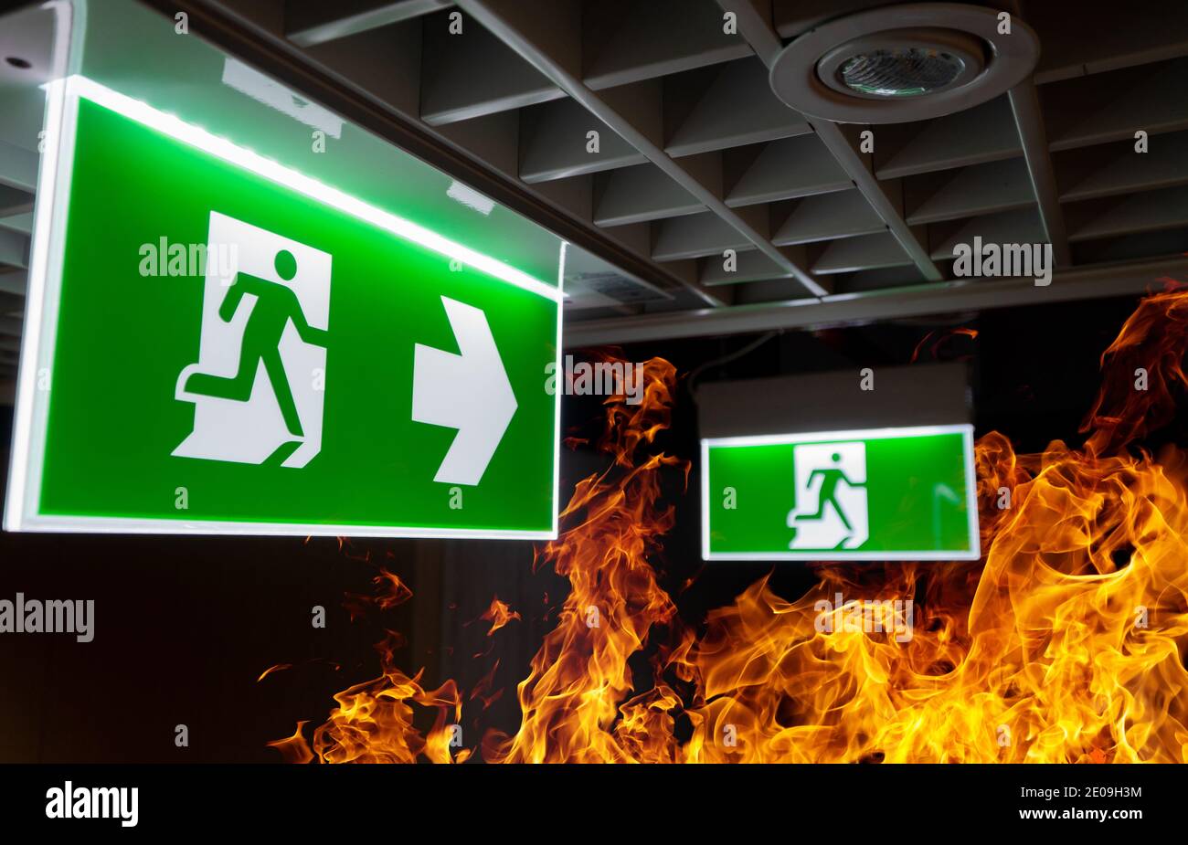 Hot flame fire and green fire escape sign hang on the ceiling in the ...