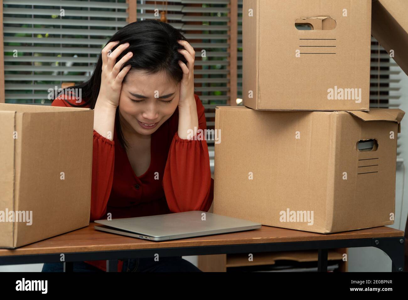 Sad Asian woman Packing belongings in a cardboard box and crying on the ...
