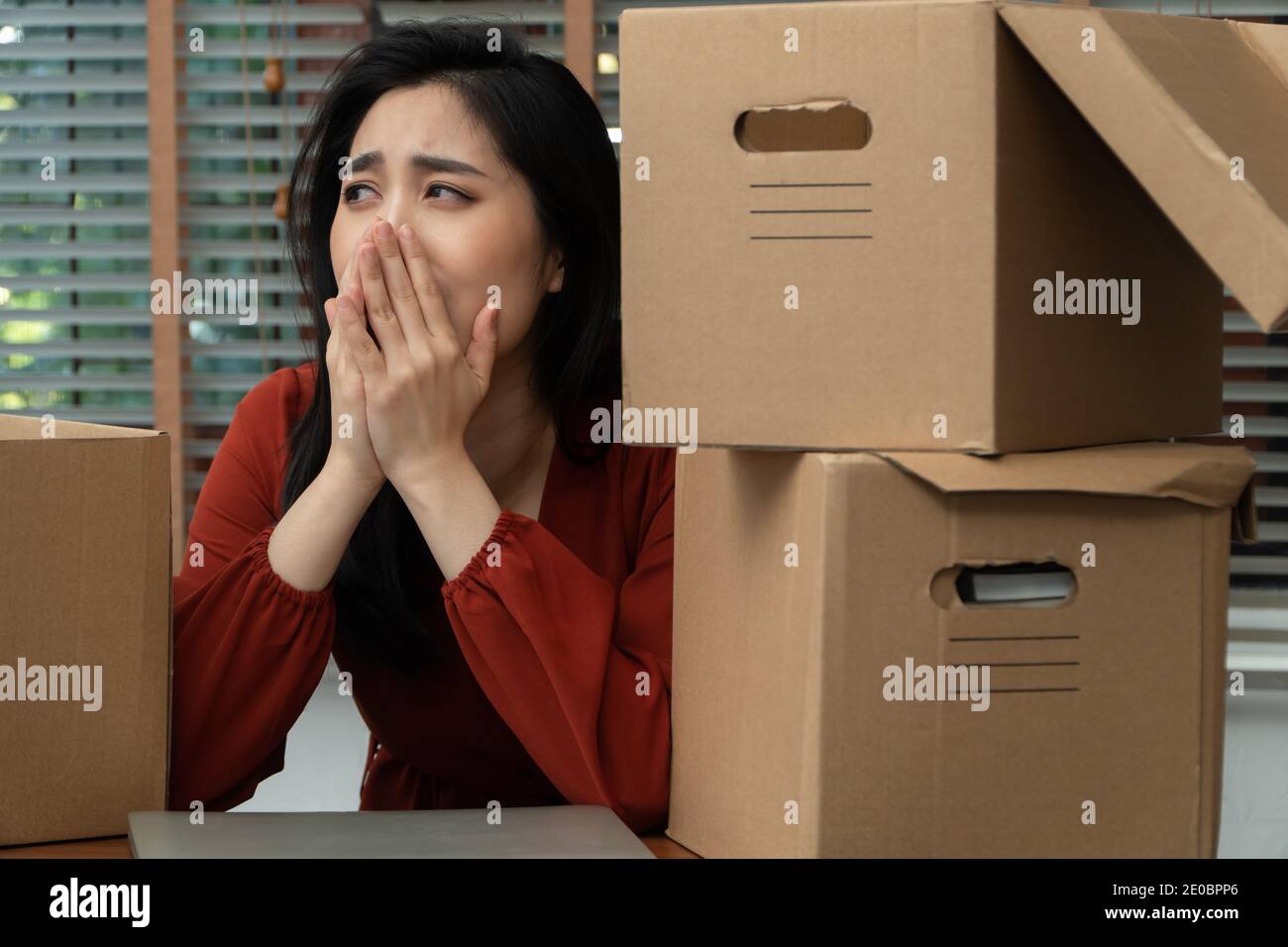 Sad Asian woman Packing belongings in a cardboard box and crying on the ...