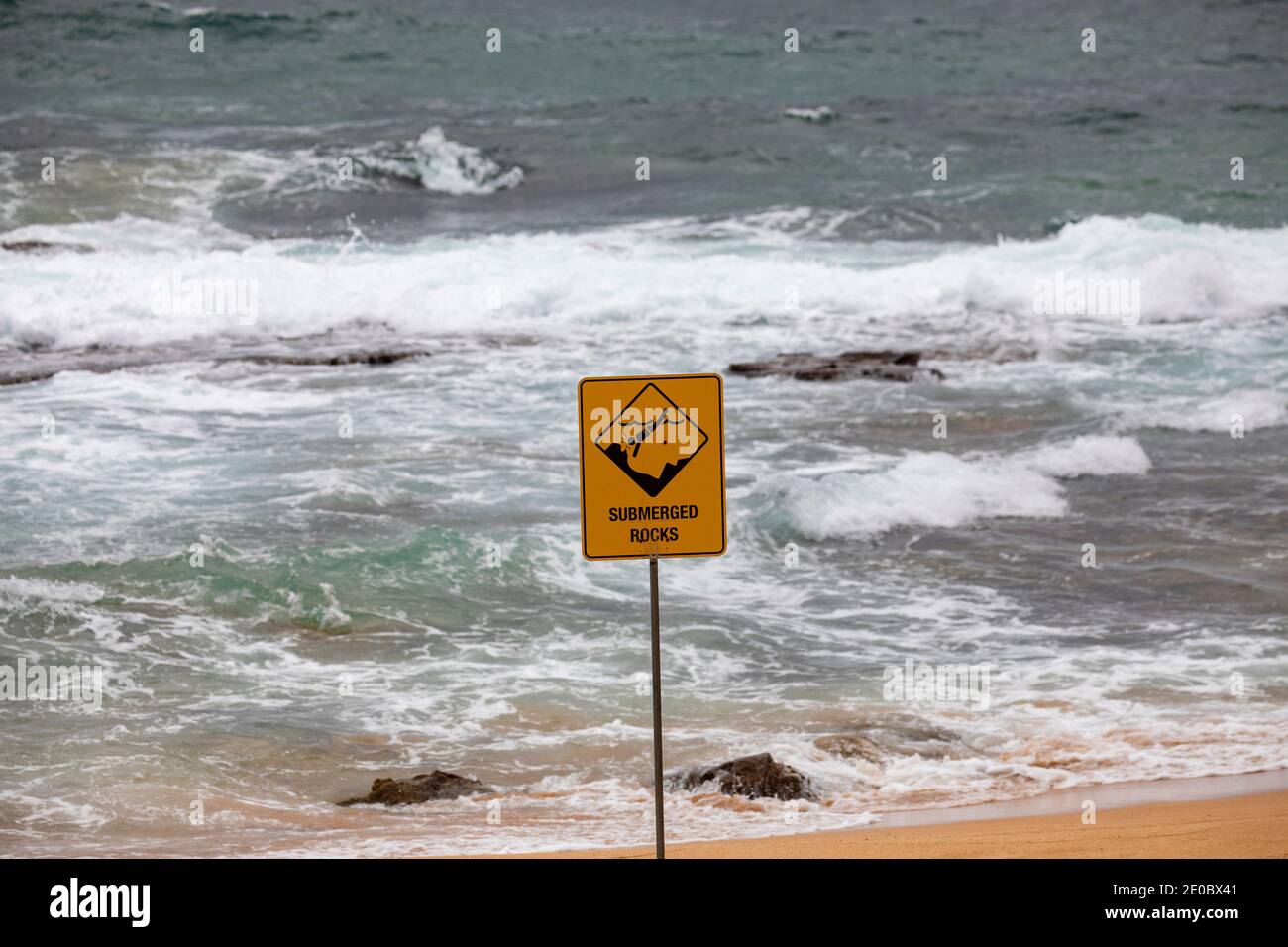 Warning submerged rocks sign advising people not to dive in the ocean ...