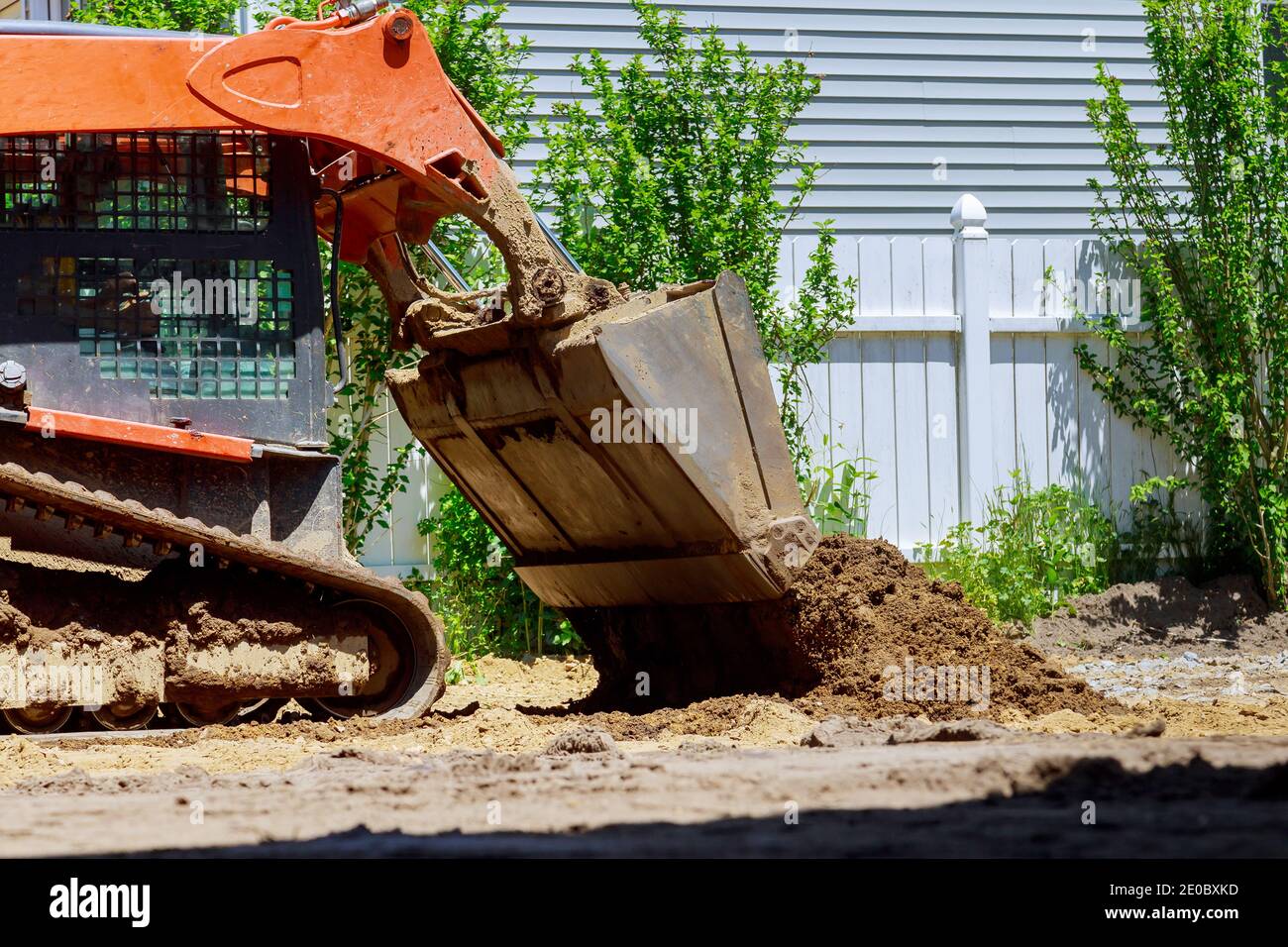 Mini bulldozer with earth doing landscaping works level the ground ...