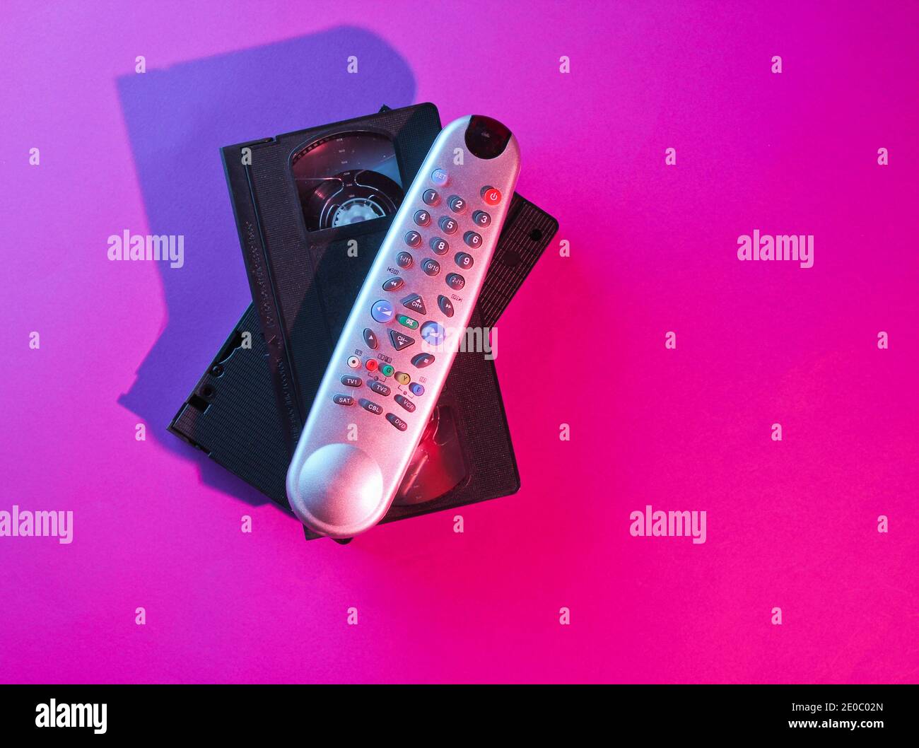Retro wave style tv remote and video cassette with neon pink-blue light ...